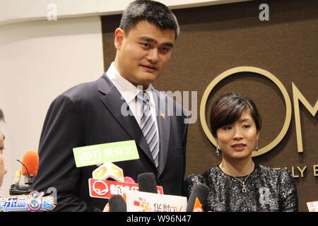 Retired Chinese basketball superstar Yao Ming, left, listens to Ye Li ...