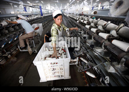 Chinese workers handle production of yarn at a textile factory in ...