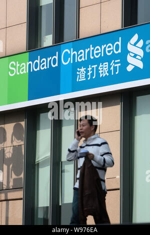 A man walks past a Standard Chartered building. (Photo by Katherine ...