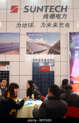 --FILE--Employees talk with visitors at the stand of Nissan during an ...