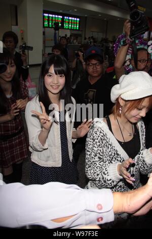 Members of Japanese pop idol girl group Morning Musume wave at a ...