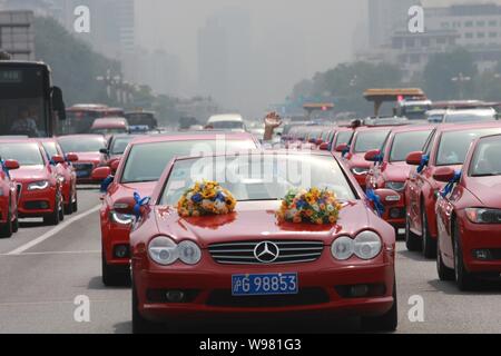 A flashy fleet of 35 red cars parade down Changan Avenue in Beijing ...