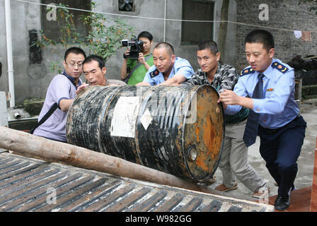 --FILE--Chinese law enforcement officers check waste oil at an illegal ...