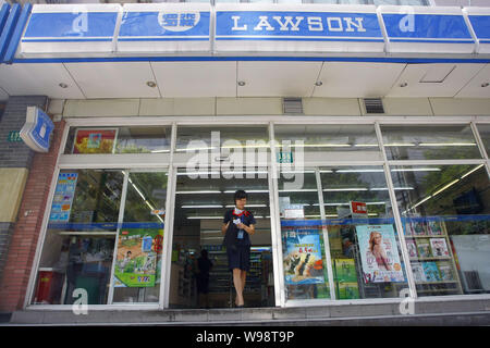 A Chinese customer walks out of a Lawson convenience store in Shanghai ...