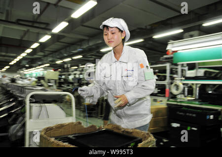Chinese Foxconn workers labor in a workshop at the Shenzhen plant of ...