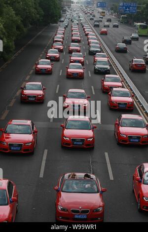 A flashy fleet of 35 red cars parade down Changan Avenue in Beijing ...