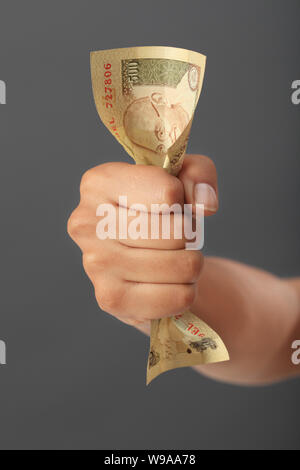 Fist crushing money Stock Photo - Alamy