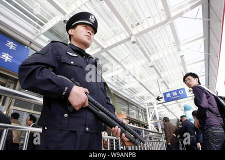 An armed Chinese policeman stands guard at the Shanghai Railway Station ...