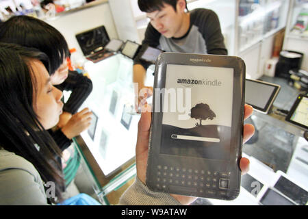 Chinese customers shop for the Amazon Kindle wireless e-book reader at ...