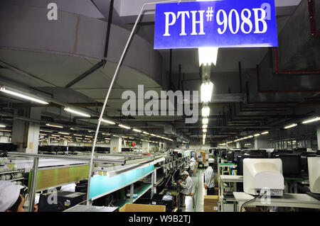 Chinese Foxconn workers labor in a workshop at the Shenzhen plant of ...