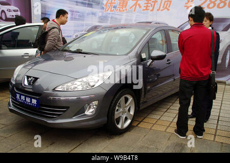 Chinese car buyers look at a Dongfeng Citroen C2 VTS at a Dongfeng ...