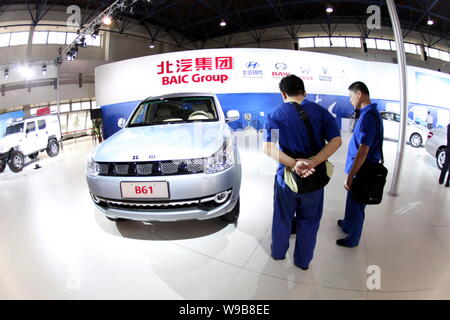 --FILE--Chinese visitors look at a B61 SUV of BAIC Group during a fair ...