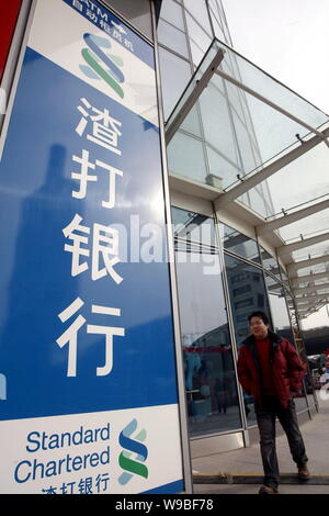 A man walks past a Standard Chartered building. (Photo by Katherine ...