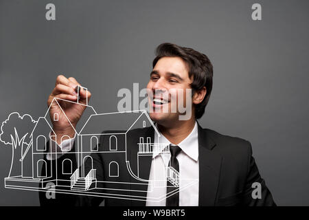 Business man drawing house on the meadow Stock Photo - Alamy