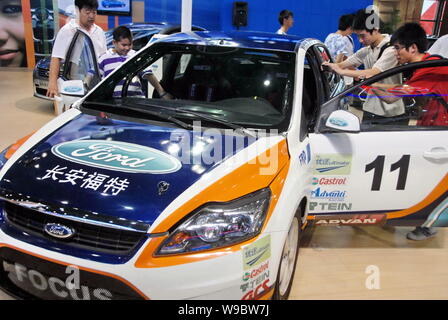 --FILE--Chinese visitors look at a Ford Focus, manufactured by ChangAn ...