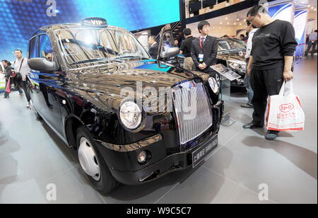 Visitors look at a Geely TX4 at the 13th Shanghai International ...