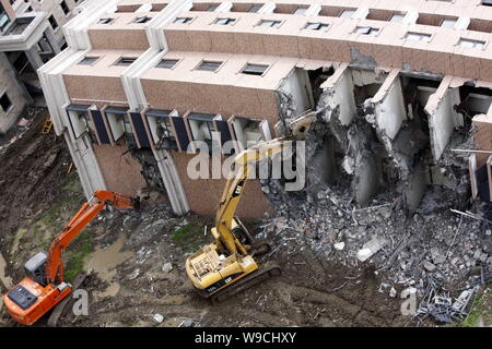 Excavators are seen dismantling the toppled apartment building at the ...