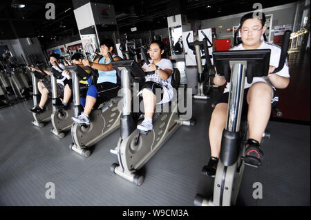 Chinese obese children exercise on steppers during a weight reduction ...