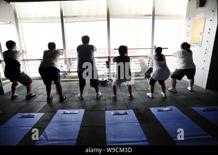 Chinese obese children exercise on steppers during a weight reduction ...
