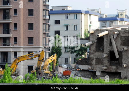 Excavators are seen dismantling the toppled apartment building at the ...
