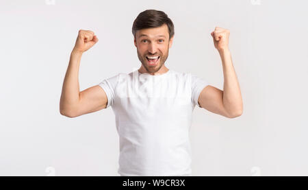 Joyful Man Shaking Fists Rejoicing Victory On White Studio Background ...