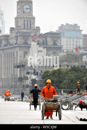 Chinese construction workers labor at the jobsite of the Bund promenade ...