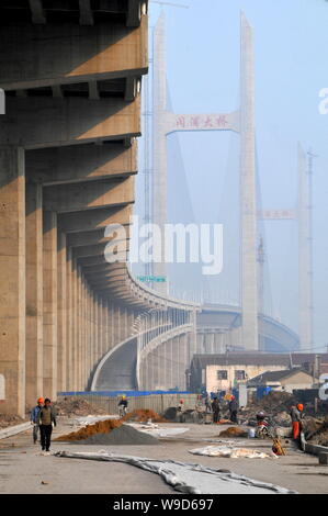 Chinese workers put final touches on the wooden sculptures of Tushanwan ...
