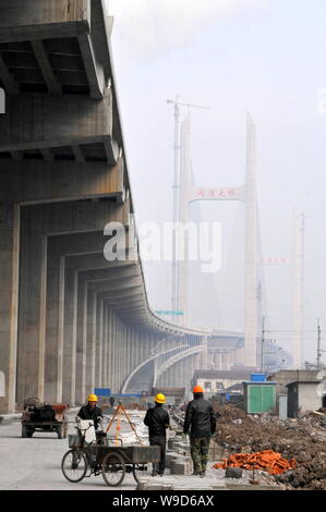 Chinese workers put final touches on the wooden sculptures of Tushanwan ...