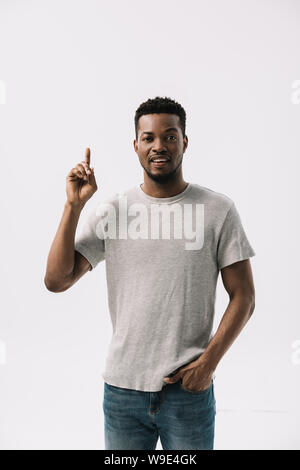 Handsome African-American man pointing at something on white background ...