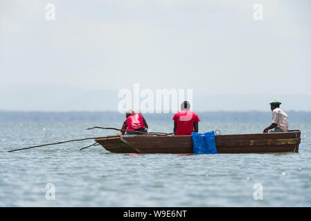 Local fishermen in small wooden boat on foreground with offshore supply ...