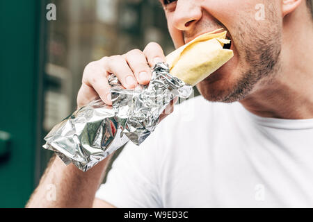 A man is eating a doner kebab Stock Photo - Alamy