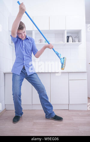 Teenager Boy Mopping The Floor and helps his parents to clean on ...