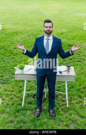 Handsome young man meditating at table in kitchen Stock Photo - Alamy