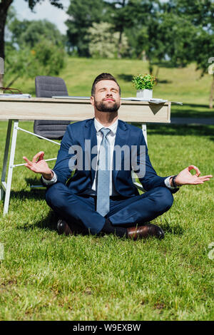 Handsome young man meditating at table in kitchen Stock Photo - Alamy