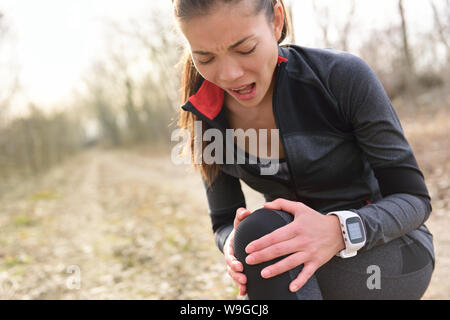 Screaming, leg injury and sports woman lying on path by beach, ocean or ...