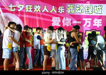 A couple of Chinese lovers kiss each other at a kiss contest to ...