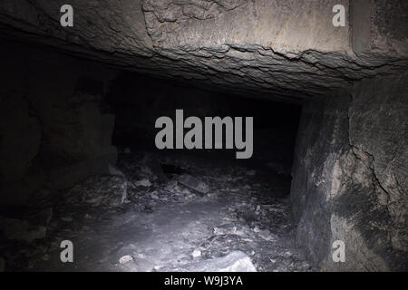 Old underground passage, dungeon, catacombs lined with stones and slabs ...