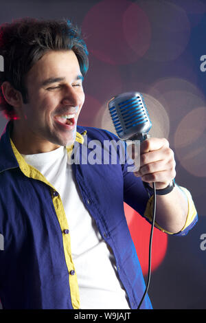 Man singing into microphone and smiling Stock Photo - Alamy