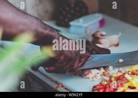 Closeup shot of an African male chopping vegetables and fruits Stock ...