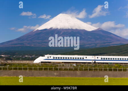 JAPAN Honshu Mount Fuji Shinkansen Bullet Train passing through harvested rice fields below the ...
