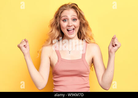Woman feeling cheerful and celebrating achievement with raised arms ...