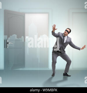 The confused businessman in front of doors Stock Photo - Alamy