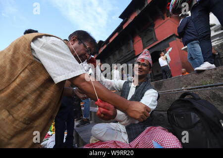 Kathmandu, Nepal. 15 August, Changing a Janai (a sacred thread). Sarita ...