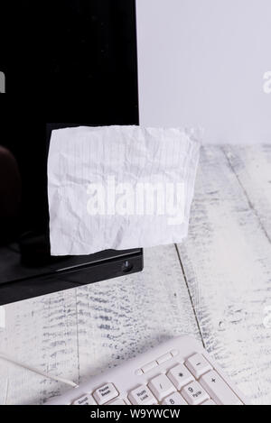 Notation paper taped to black computer monitor screen near white ...