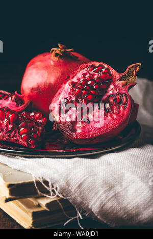 Ripe pomegranate fruit on a old black wooden vintage background ...