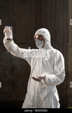ecologist in protective costume and respirator touching tree in forest ...