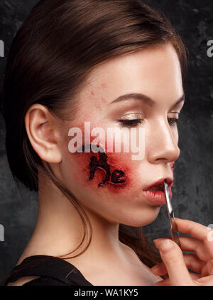 Scary man with bloody scars face, Halloween zombie showing golden ...