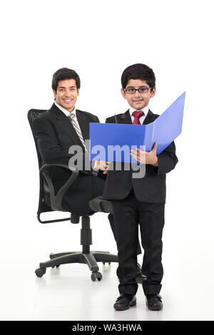 Boy imitating as a businessman and standing with his father Stock Photo ...