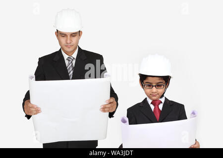 Boy imitating as architect and standing with his father Stock Photo - Alamy