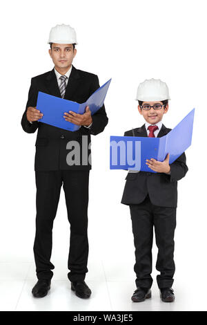 Boy imitating as architect and standing with his father Stock Photo - Alamy